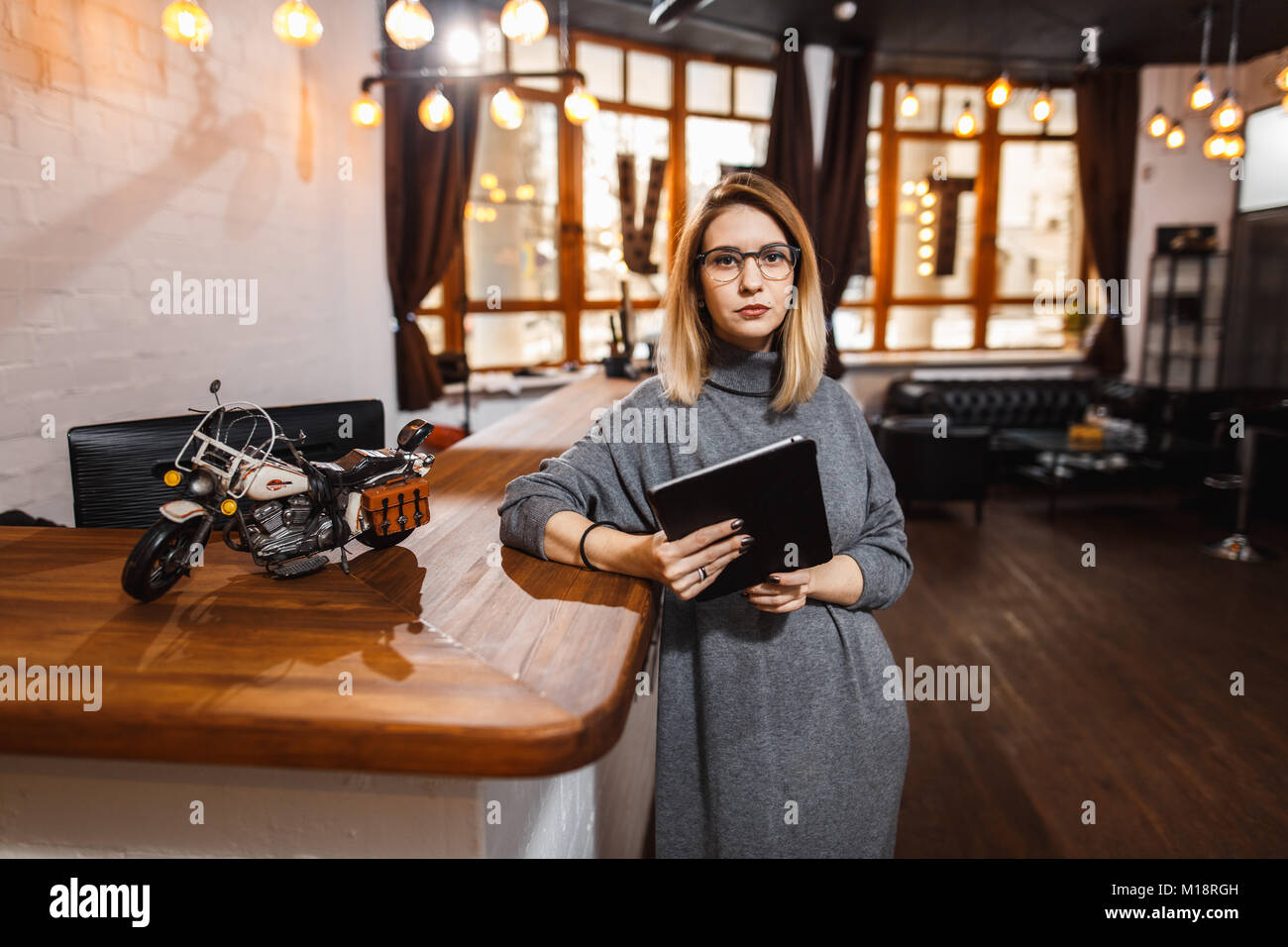 Receptionist standing at reception counter in office Stock Photo - Alamy