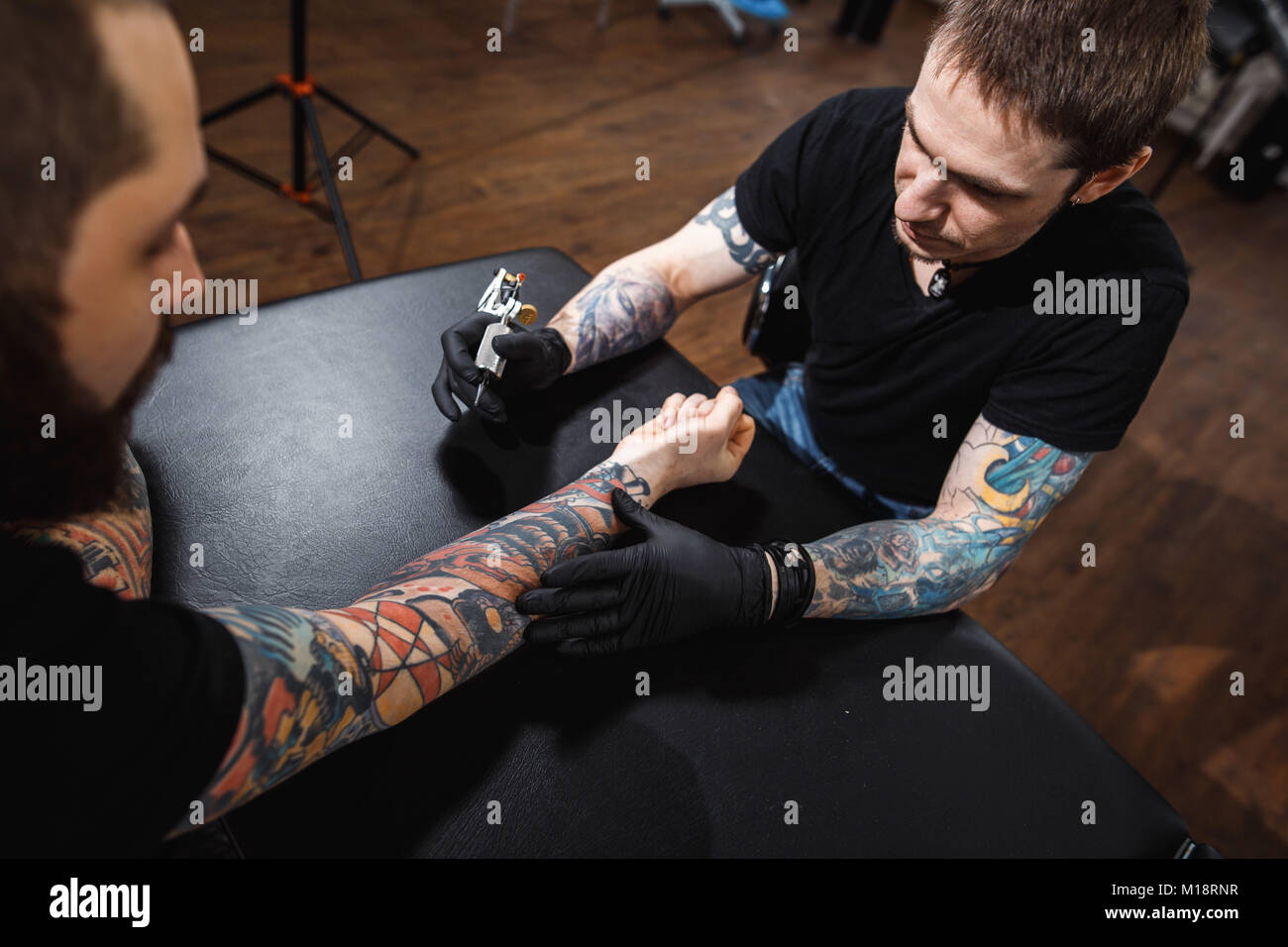 master tattooist makes a tattoo on the skin of the client with special ...