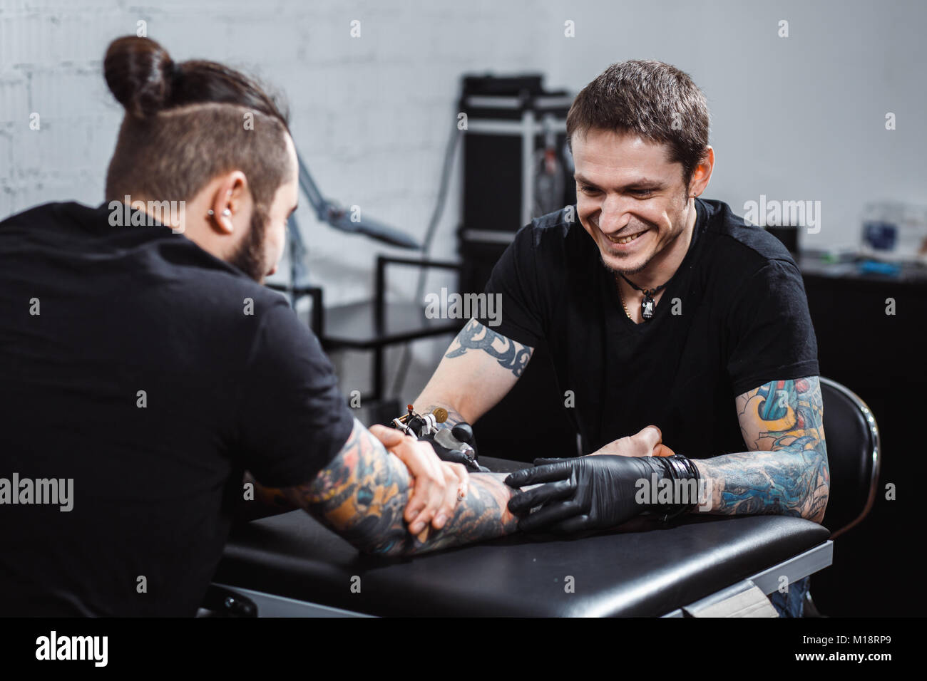 master tattooist makes a tattoo on the skin of the client with special ...