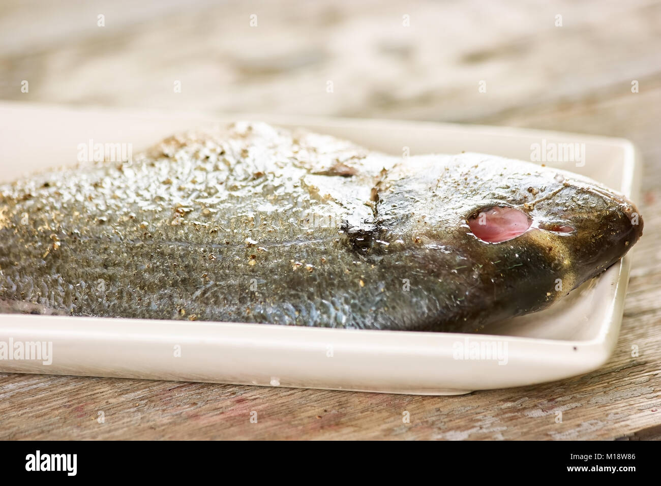 Raw fish on plate closeup Stock Photo - Alamy