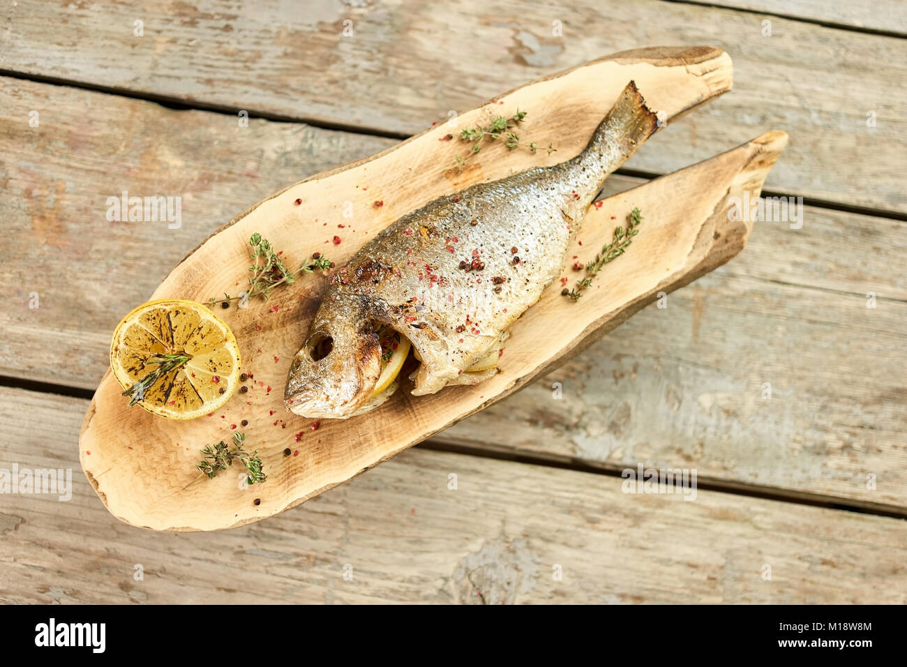 Cooked fish on a wooden plate, top view Stock Photo - Alamy