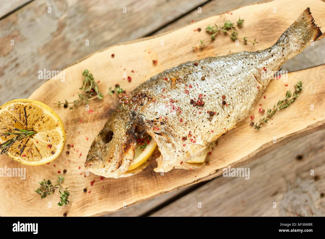 Roasted fish with garnish, closeup Stock Photo - Alamy