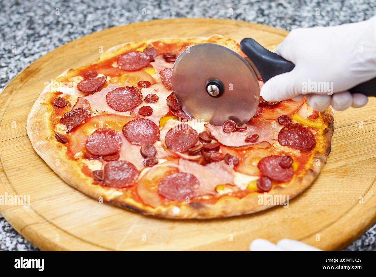 Pizza cutting using wheel cutter Stock Photo - Alamy