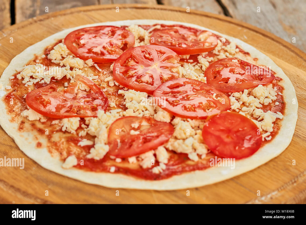 Unbaked tomato pizza Stock Photo - Alamy