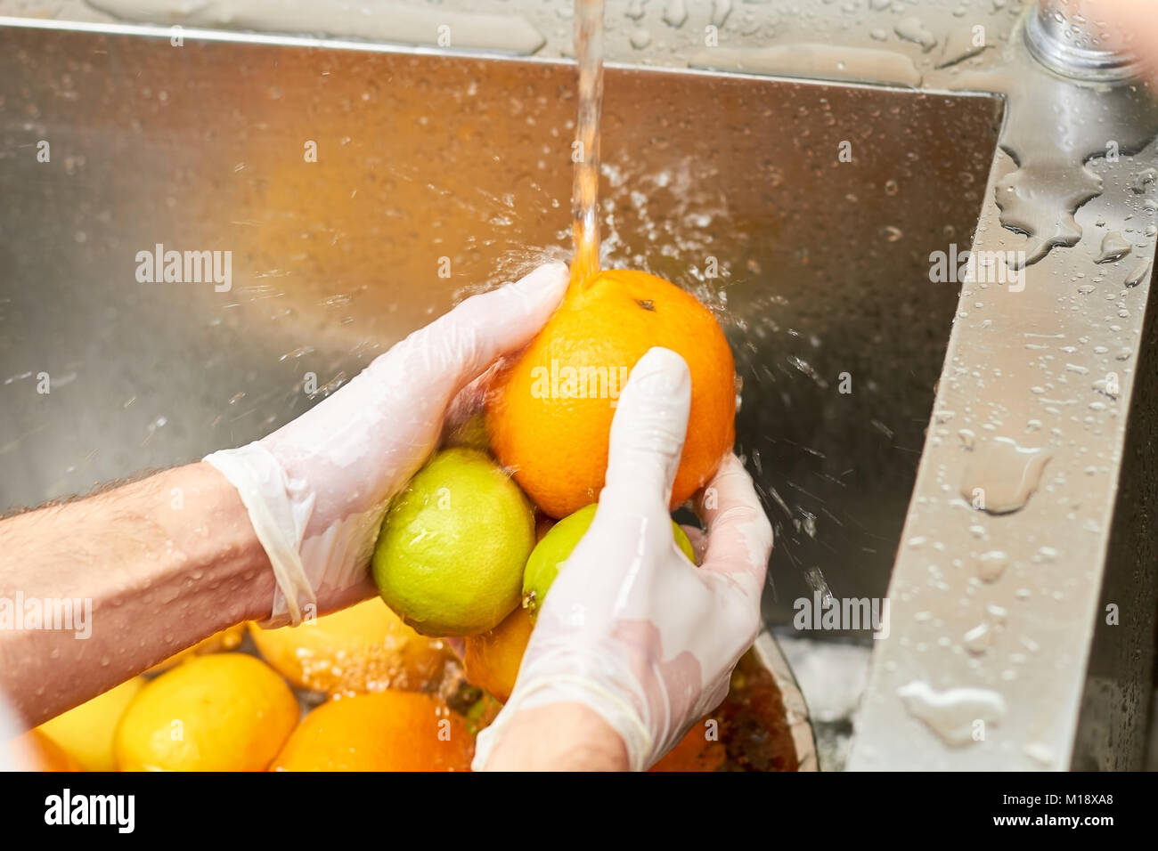 Chef washing citrus fruits in a sink Stock Photo - Alamy