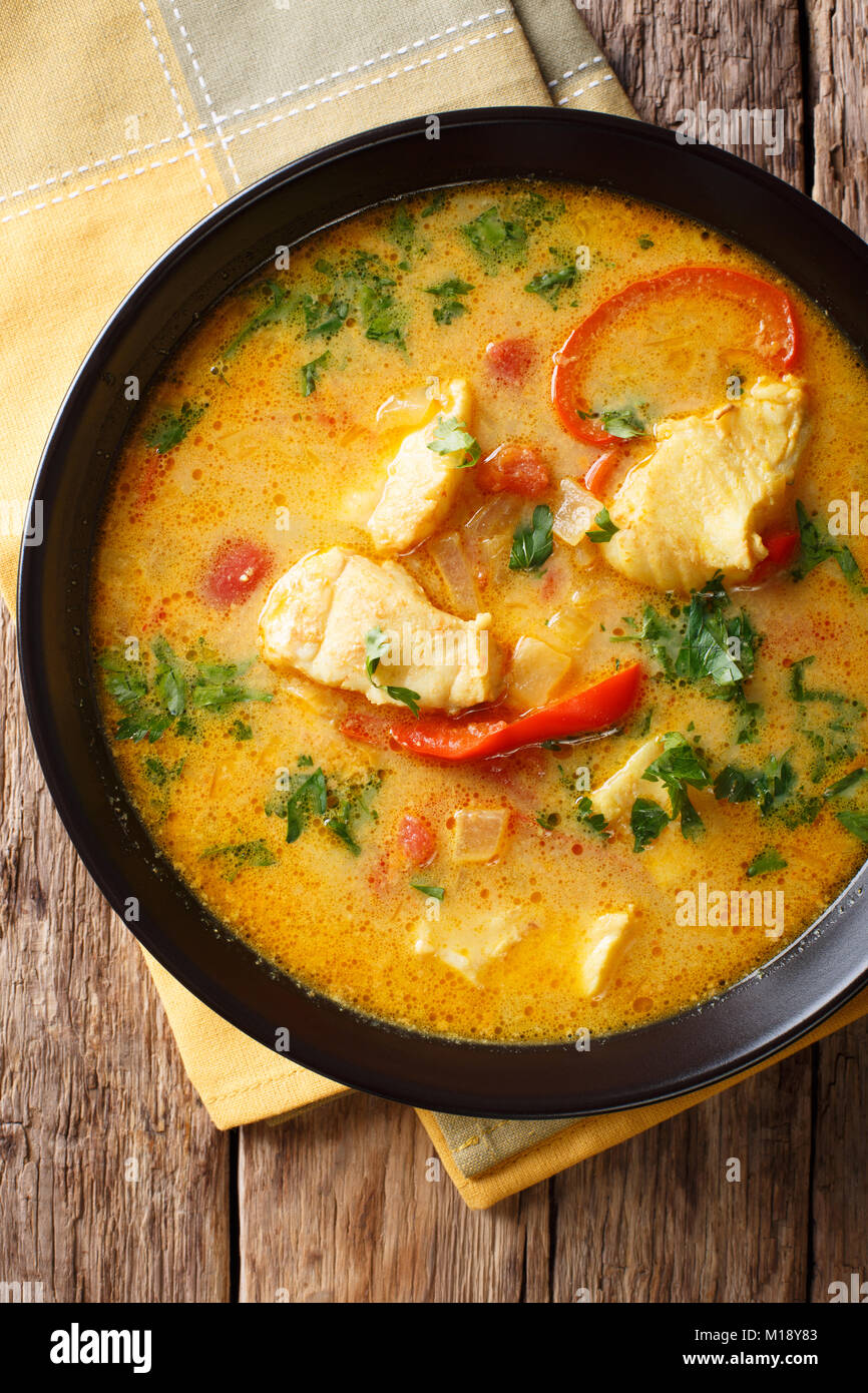 Brazilian stew fish with vegetables and coconut milk close-up in a bowl ...