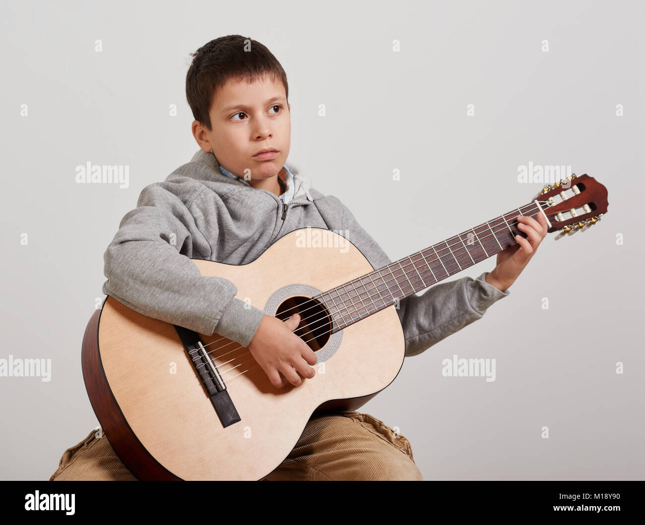 Boy is playing the acoustic guitar on white background Stock Photo - Alamy