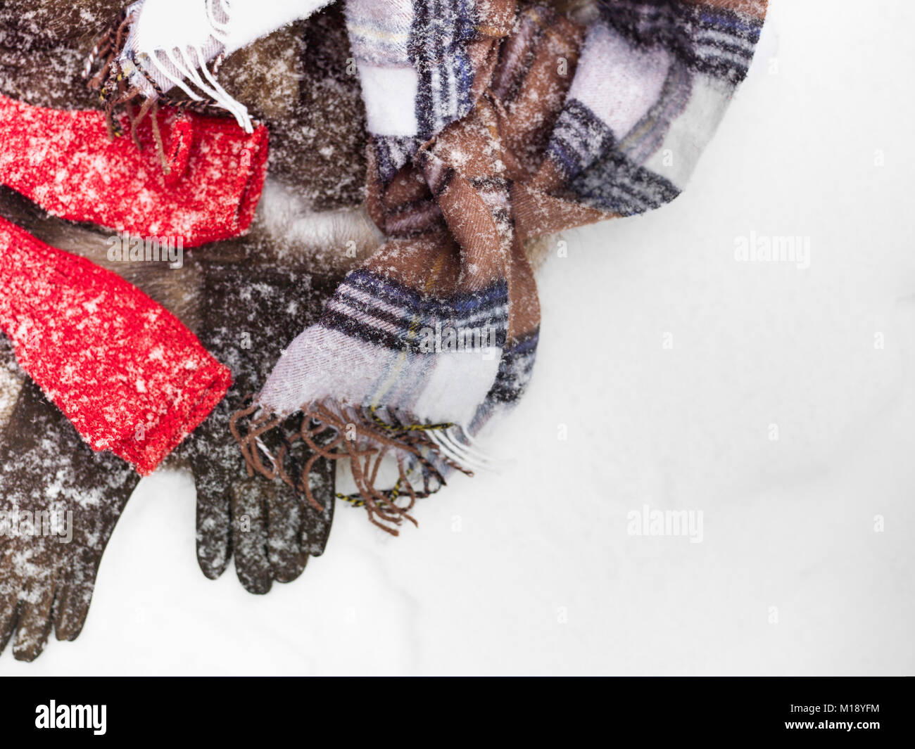 Bunch of winter garments and clothes laid under falling snow, above ...