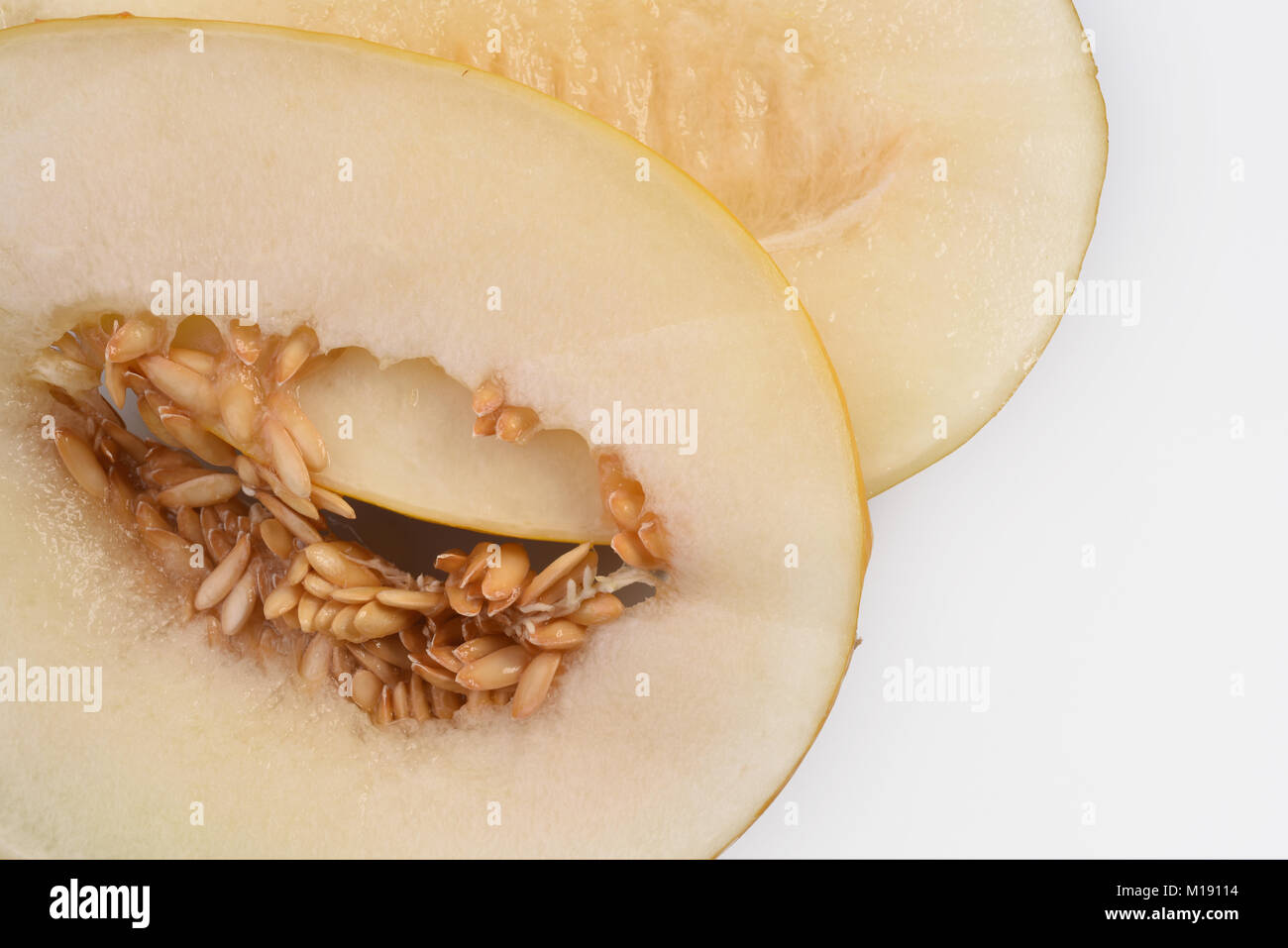 Fresh cut into layers of yellow melon on white background, on the right ...