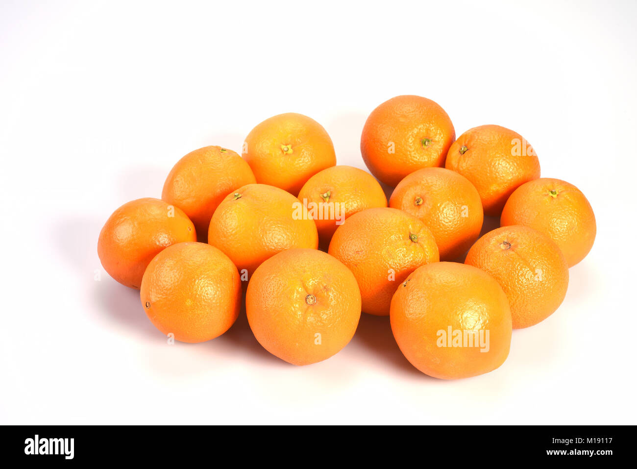 A lot of bright orange orange lie in a bunch on a white background, raw ...