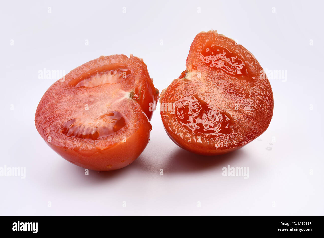 Two halves of a fresh red rustic tomato on a white background Stock ...