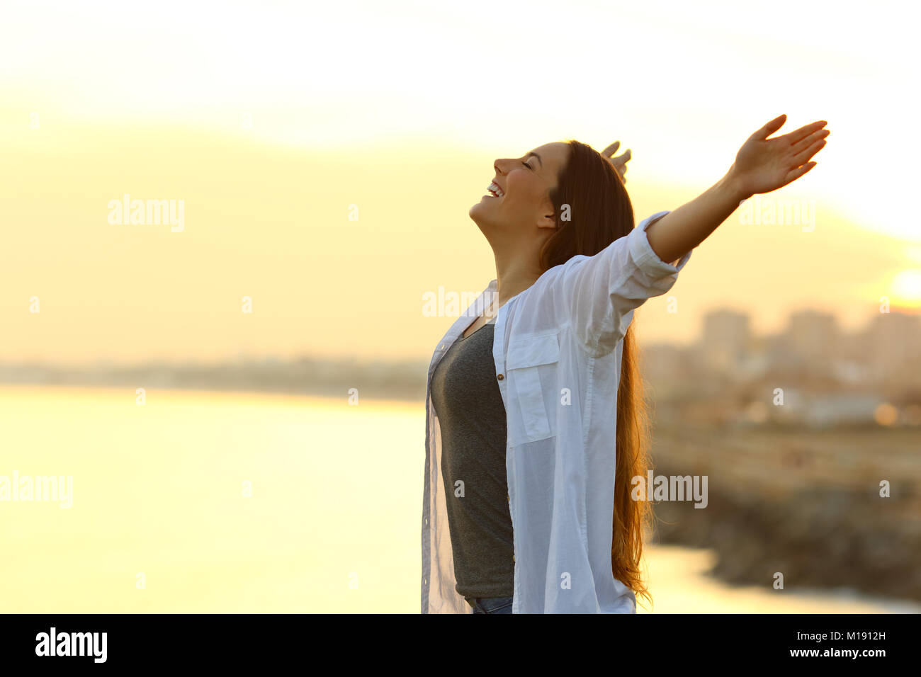 Side view portrait of a woman breathing deep fresh air outstretching ...