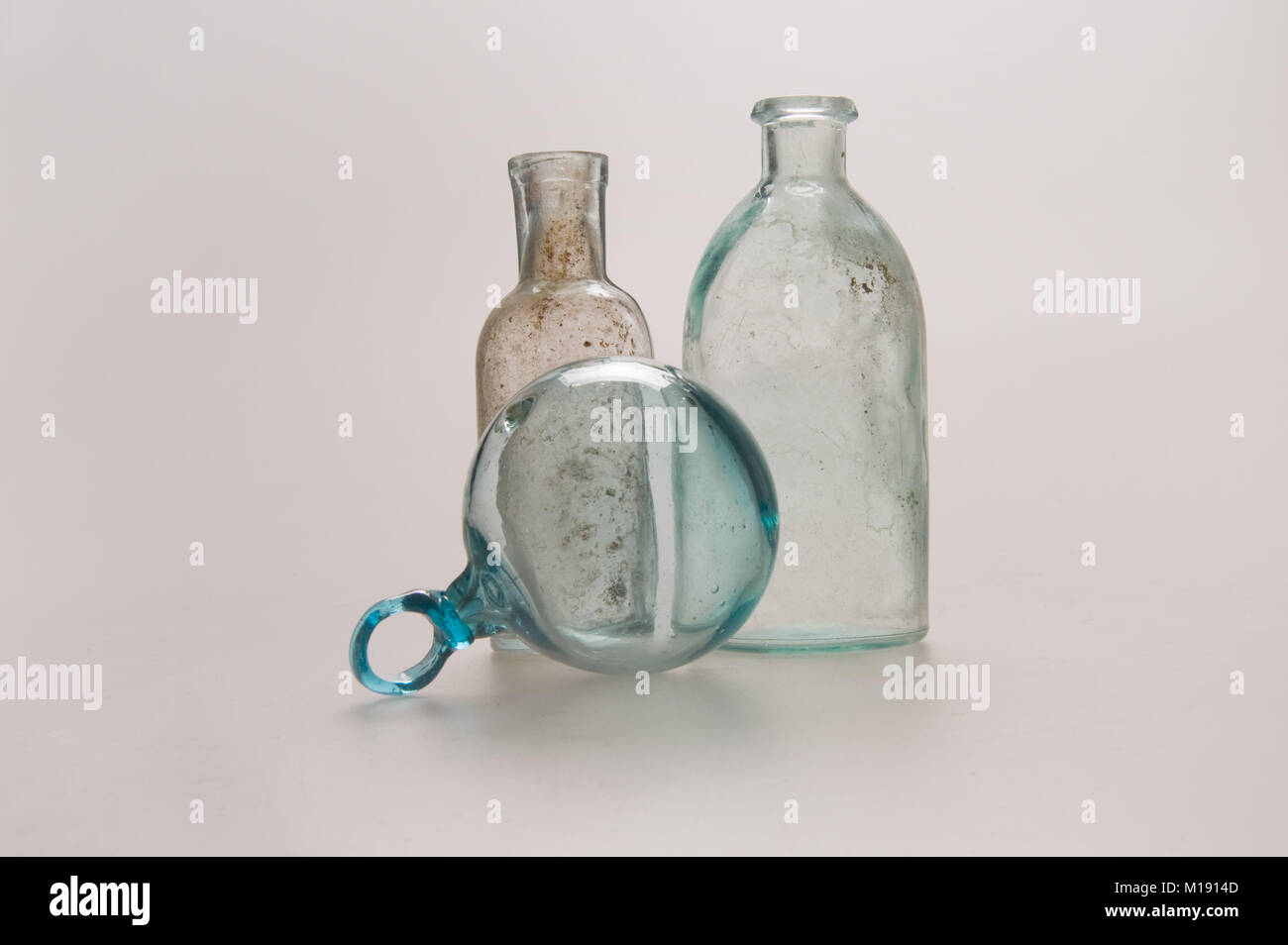 Still-life of three transparent objects: two antique bottles and an ...