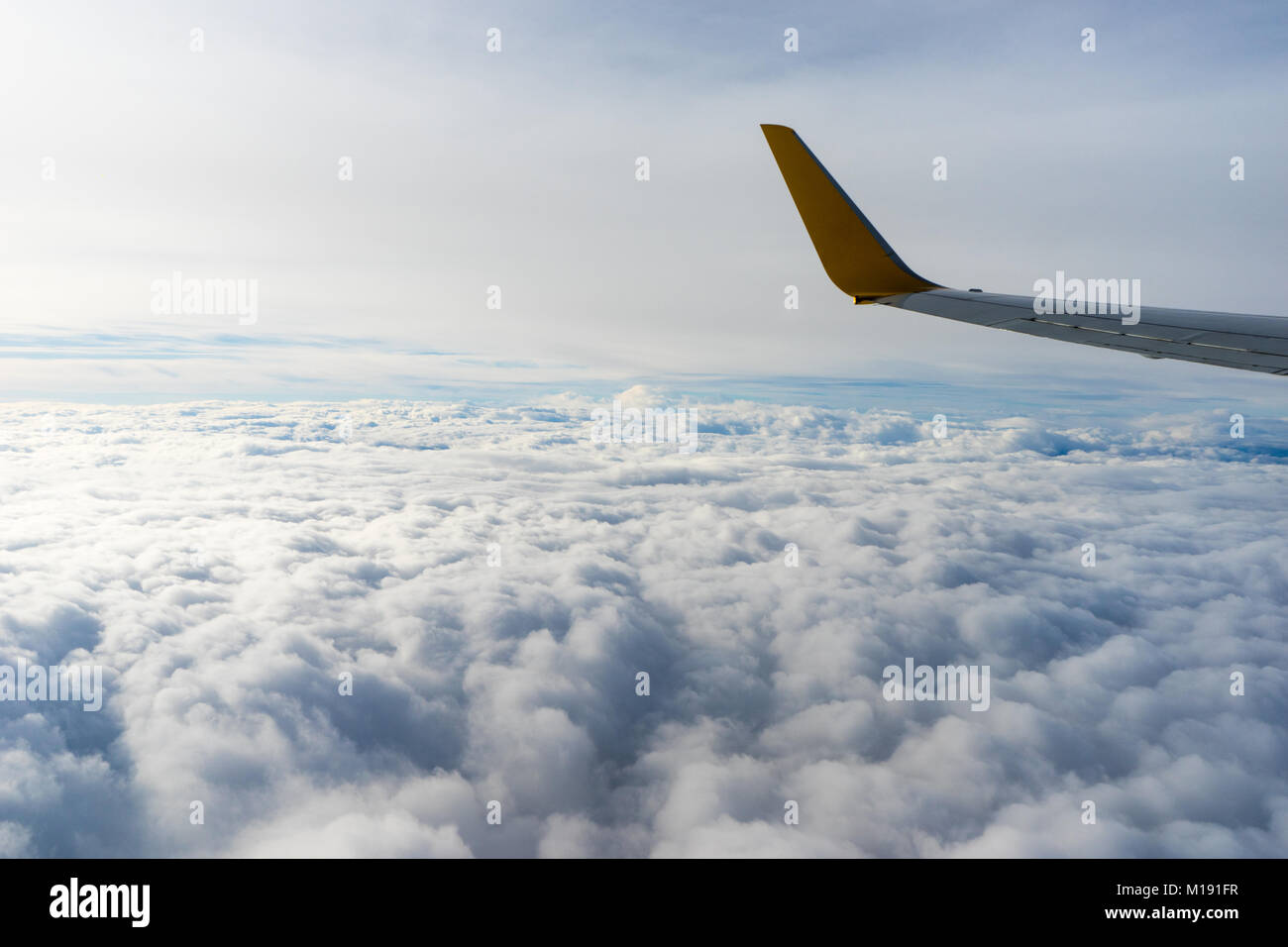 Clouds and wing, view from the window of airplane flying in the clouds ...