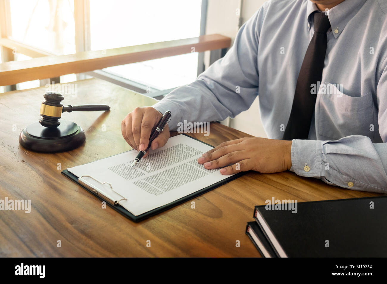 lawyer hand writes the document in court (justice, law) with sounding ...