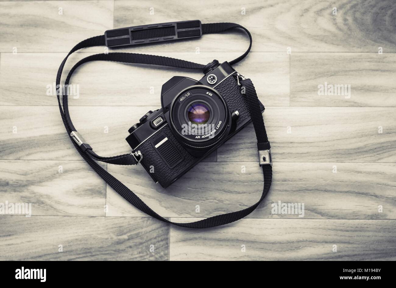 an old camera with a flash installed in the middle of a brown wooden ...