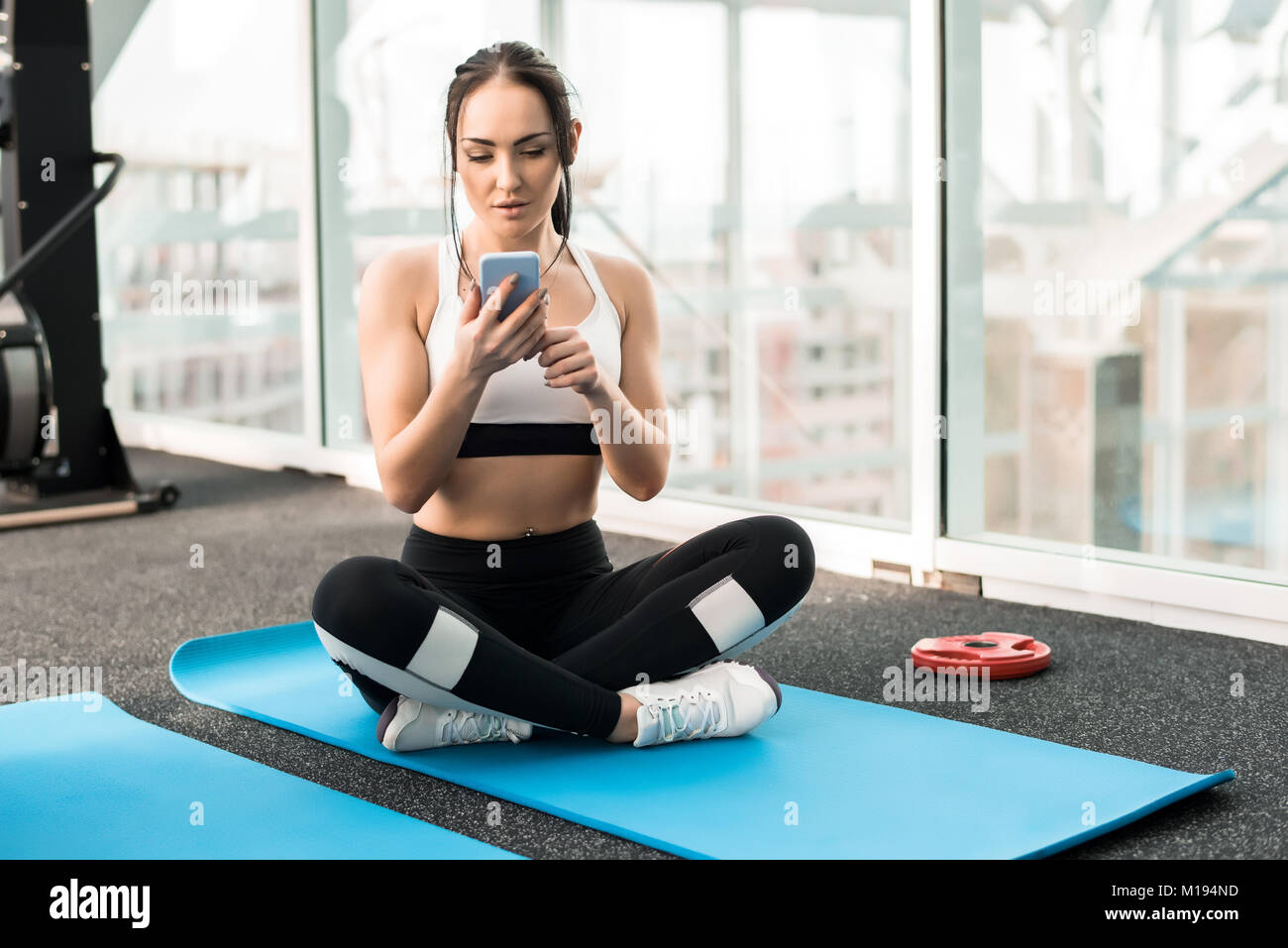 Woman Using Smartphone in Gym Stock Photo - Alamy