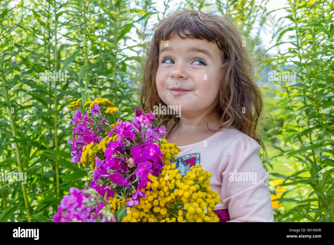 Girl playing on the flower field Stock Photo - Alamy