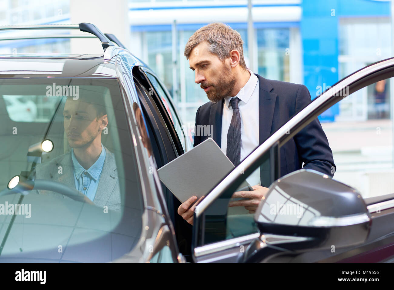 Man Testing New Car in Showroom Stock Photo - Alamy