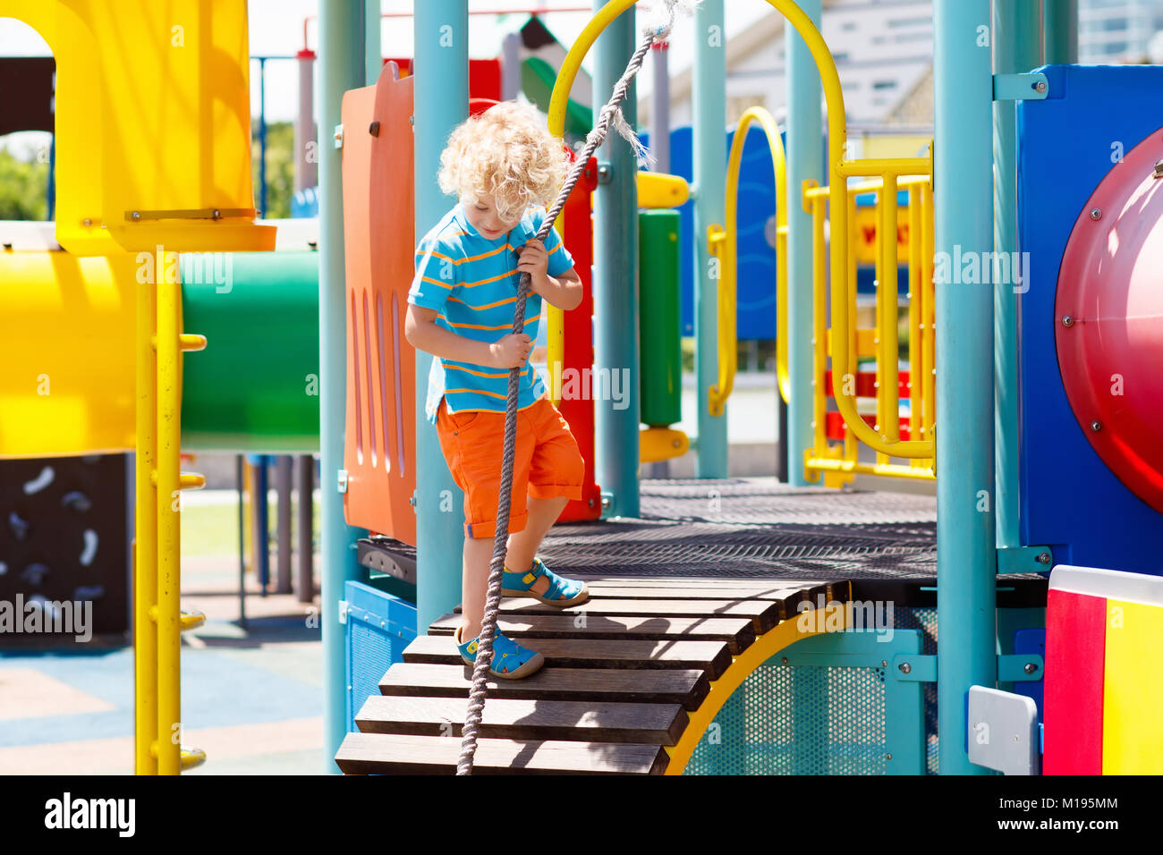 Kids climbing and sliding on outdoor playground. Children play in sunny ...