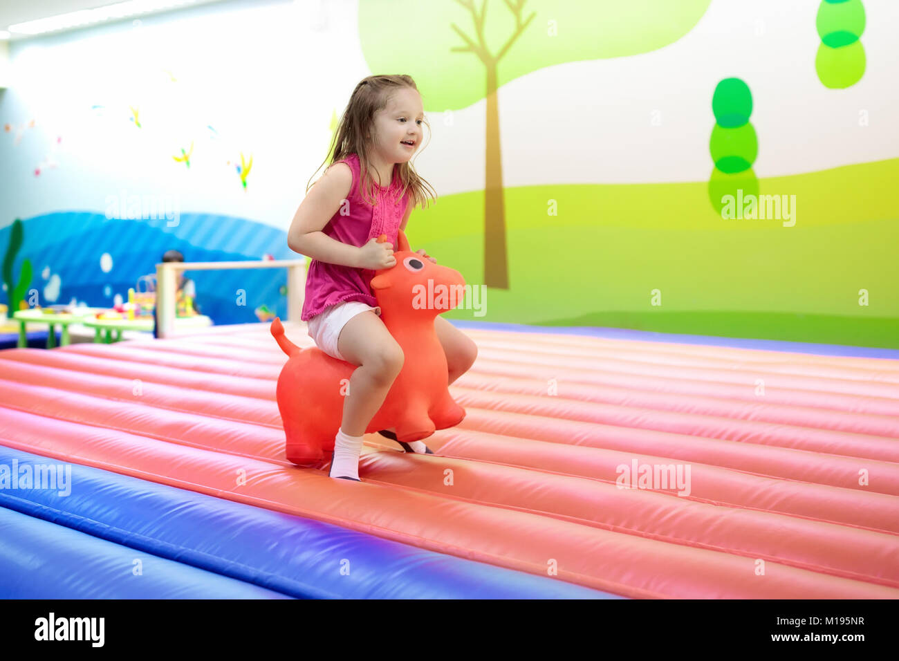 Child jumping on colorful playground trampoline. Kids jump in ...