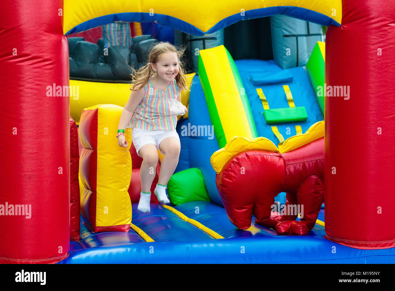 Child jumping on colorful playground trampoline. Kids jump in ...