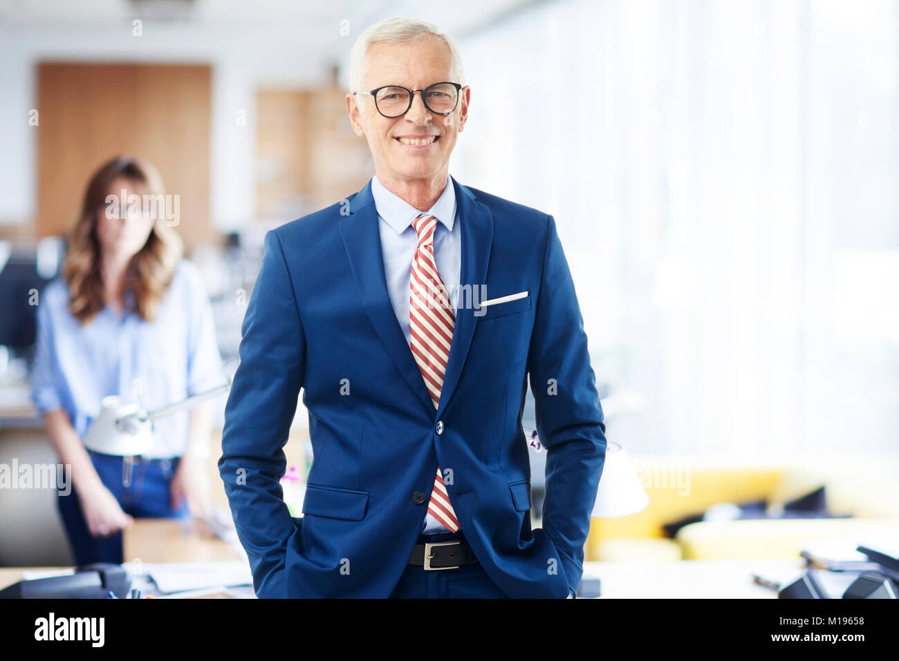 A happy senior financial director businessman standing at the office ...