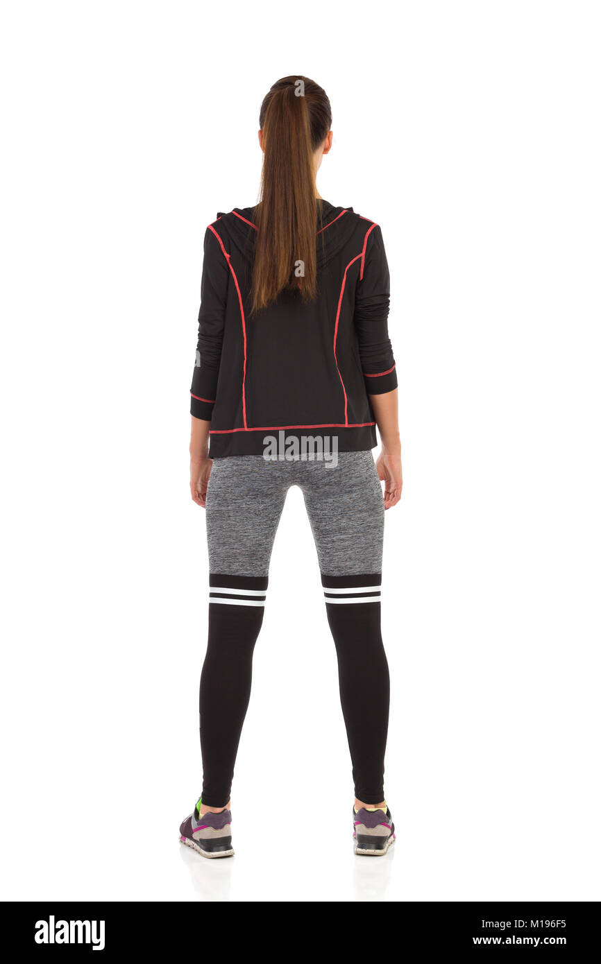 Rear view of young woman in fitness clothes. Full length studio shot ...