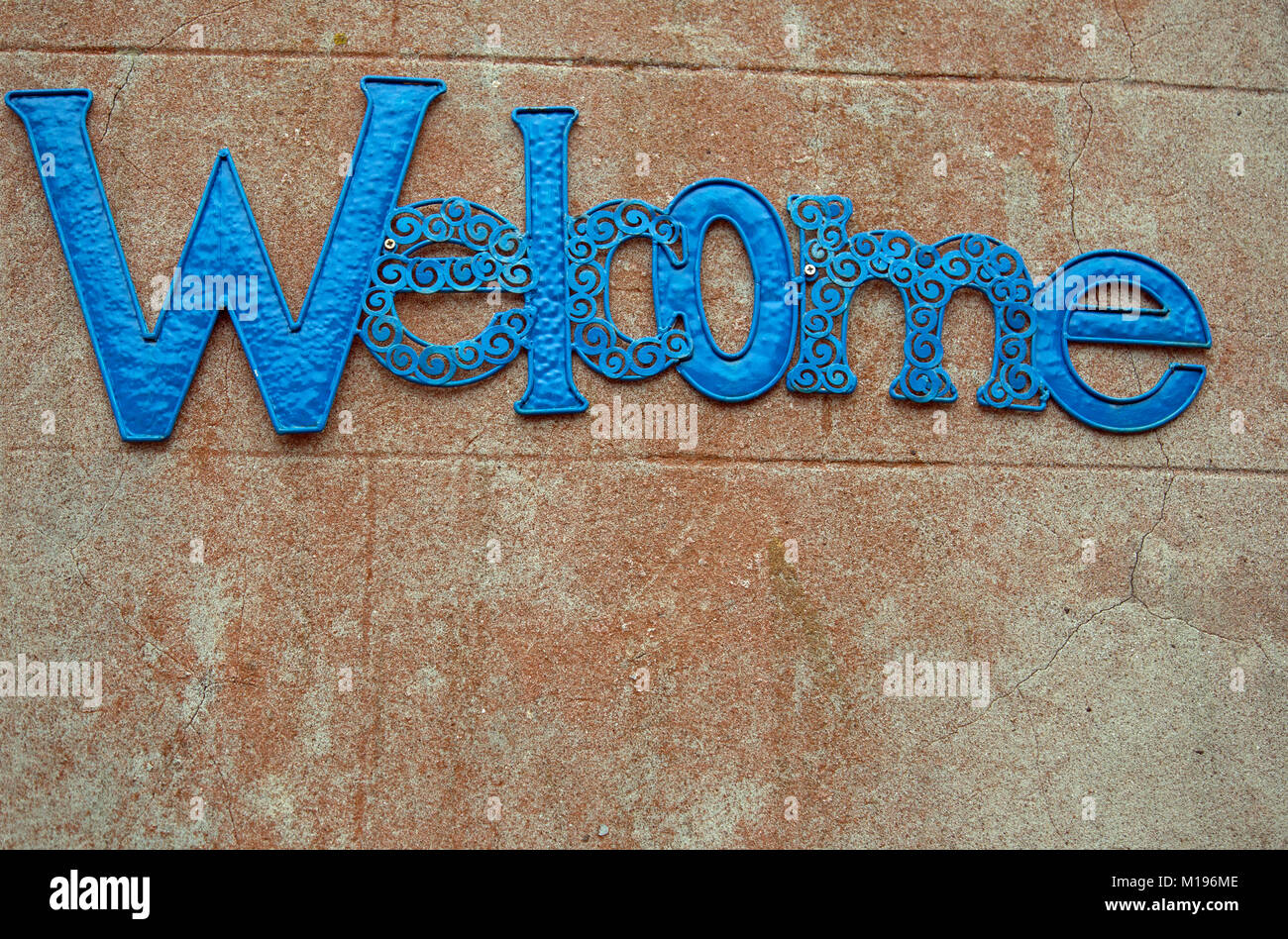 Painted blue Welcome sign fixed to a textured background wall Stock ...
