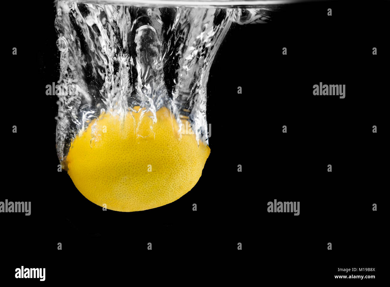 Lemon falls into the water and makes a splash Stock Photo - Alamy