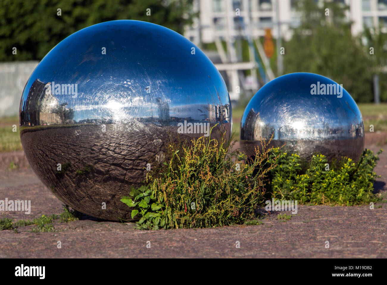 The sun with street is reflected in a two shiny steel ball, Helsinki ...
