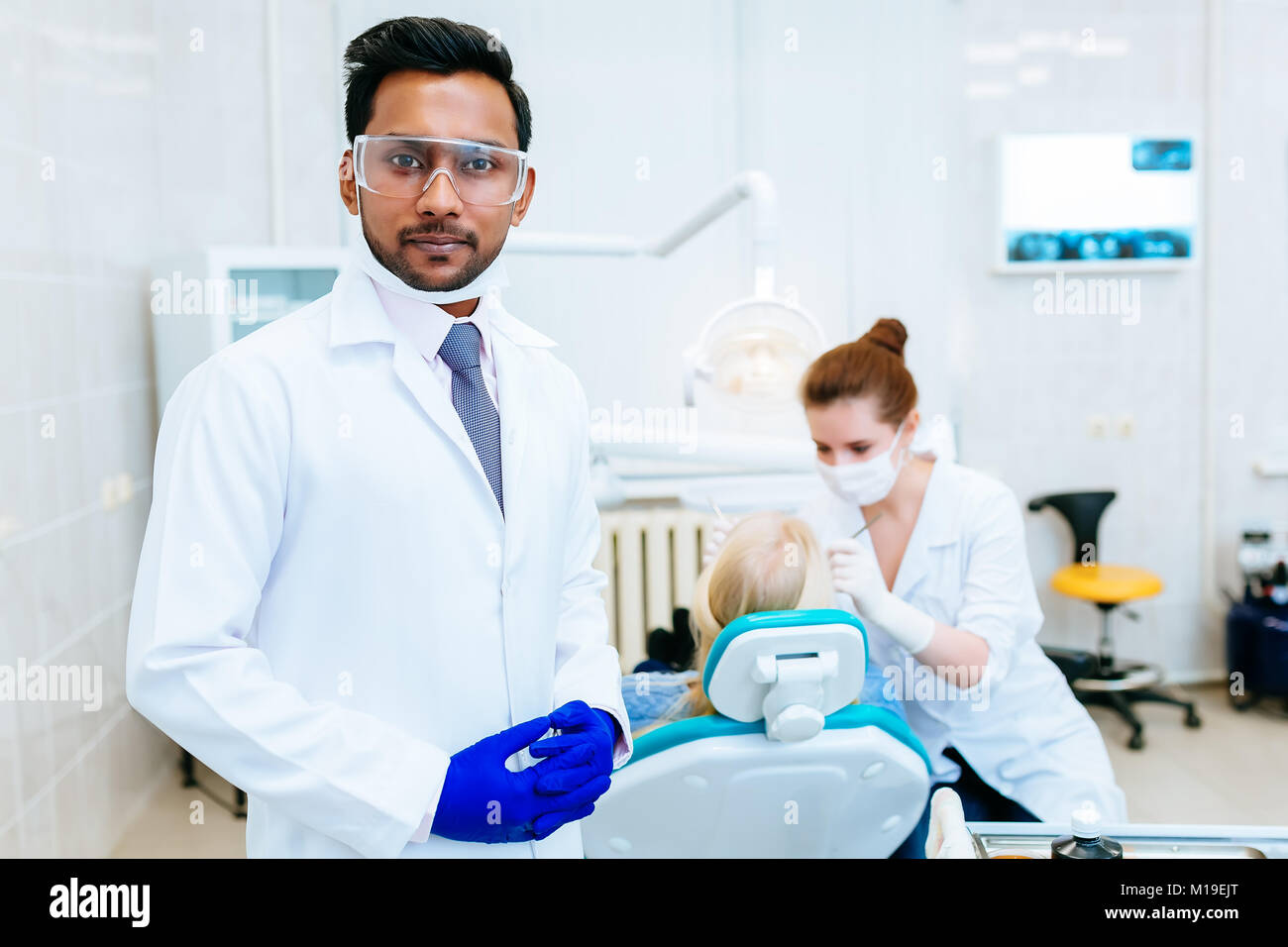 Dentist checking patients teeth Portrait of a young confident indian ...
