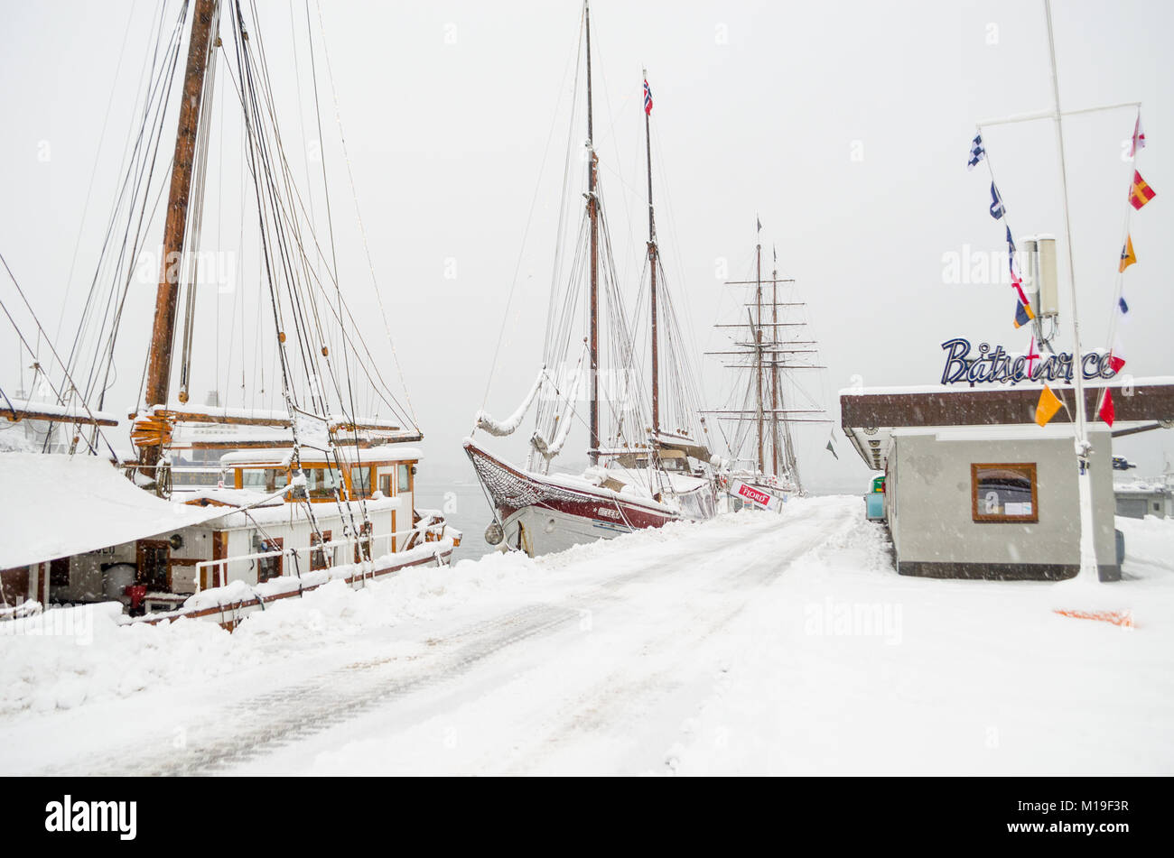 Snow covered sailling ships in Oslo harbour during heavy snow storm ...