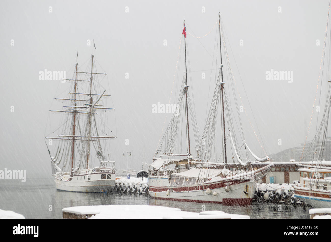 Snow covered sailling ships in Oslo harbour during heavy snow storm ...