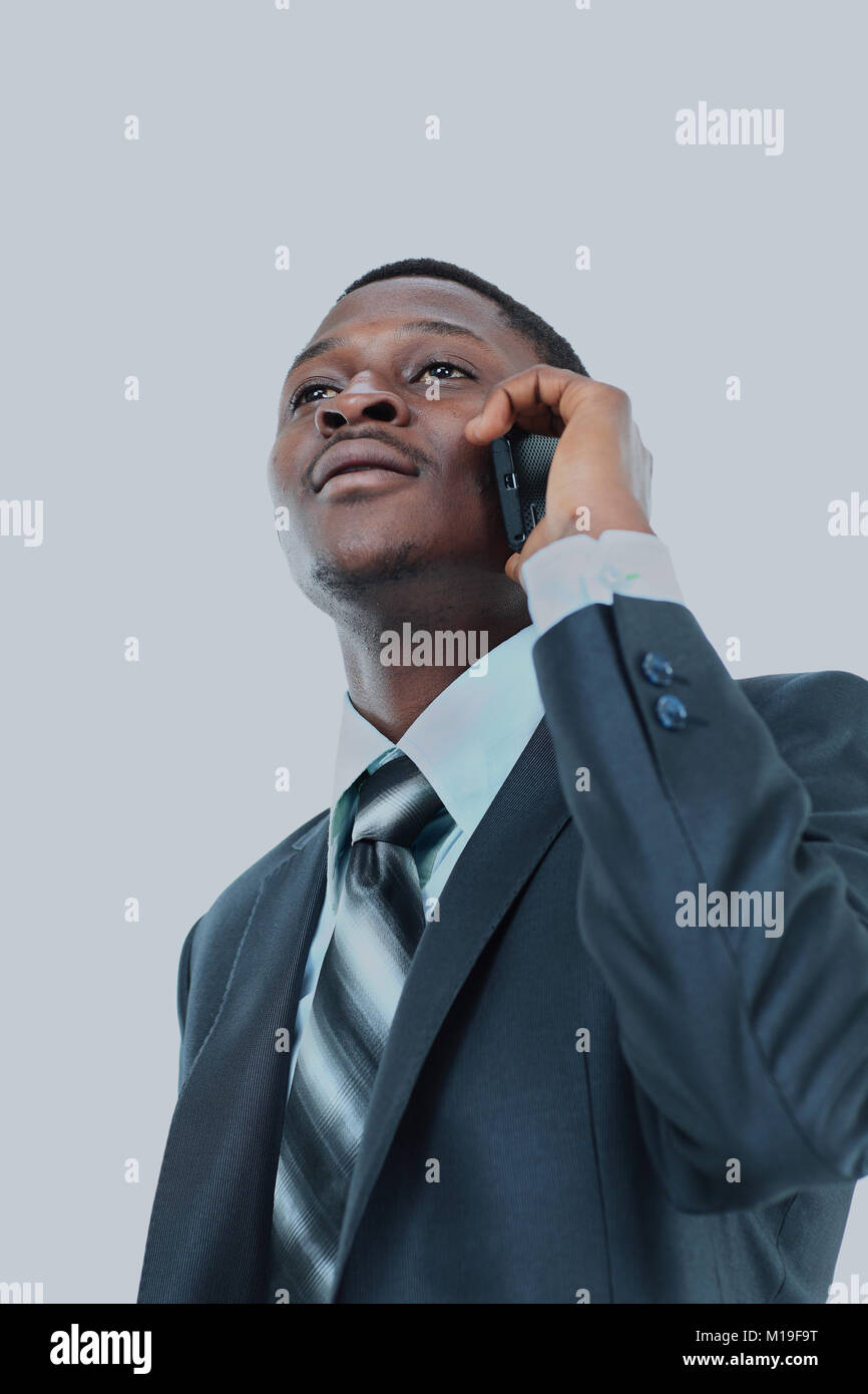 Young entrepreneur holding his coat over shoulder while talking on cell ...