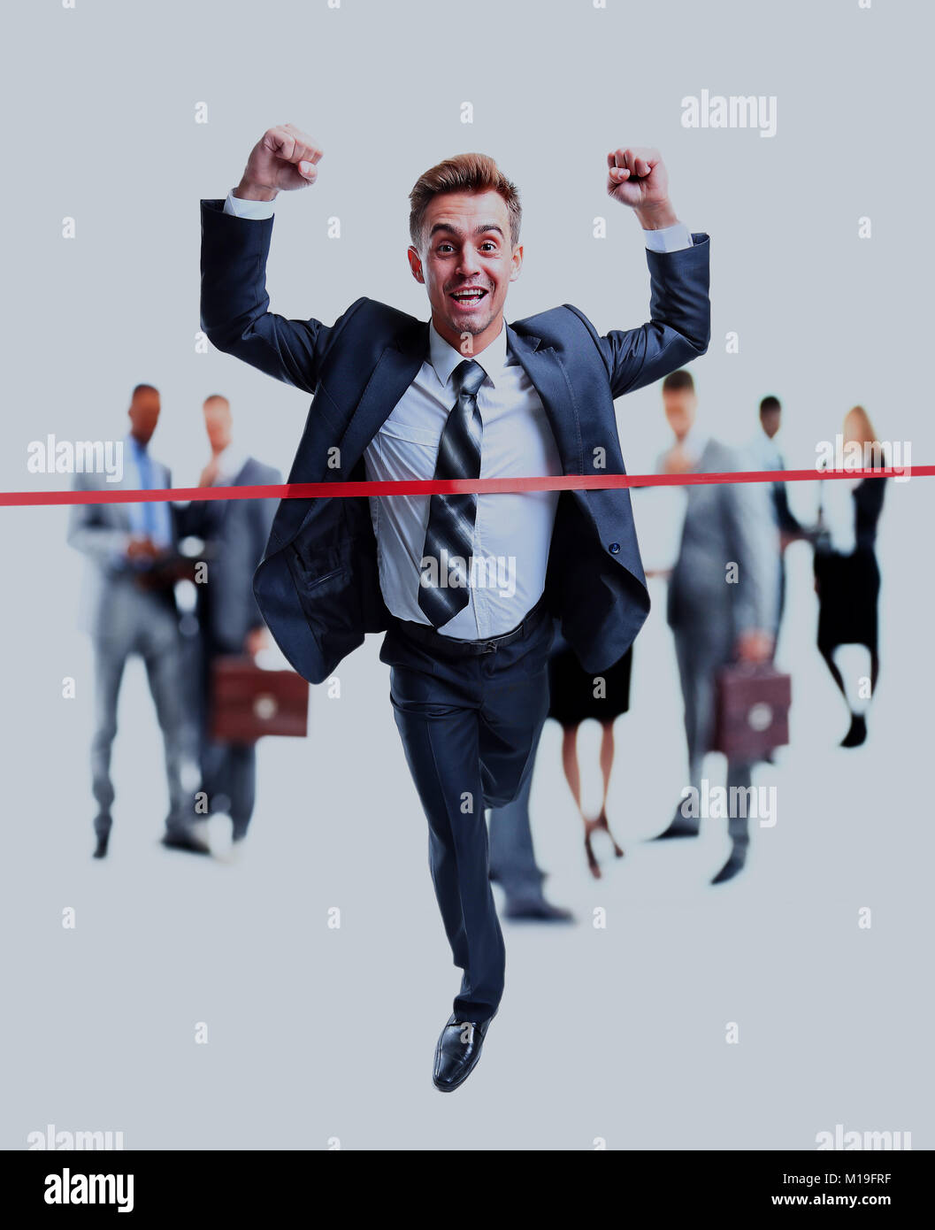 Happy businessman running through finishing line Stock Photo - Alamy