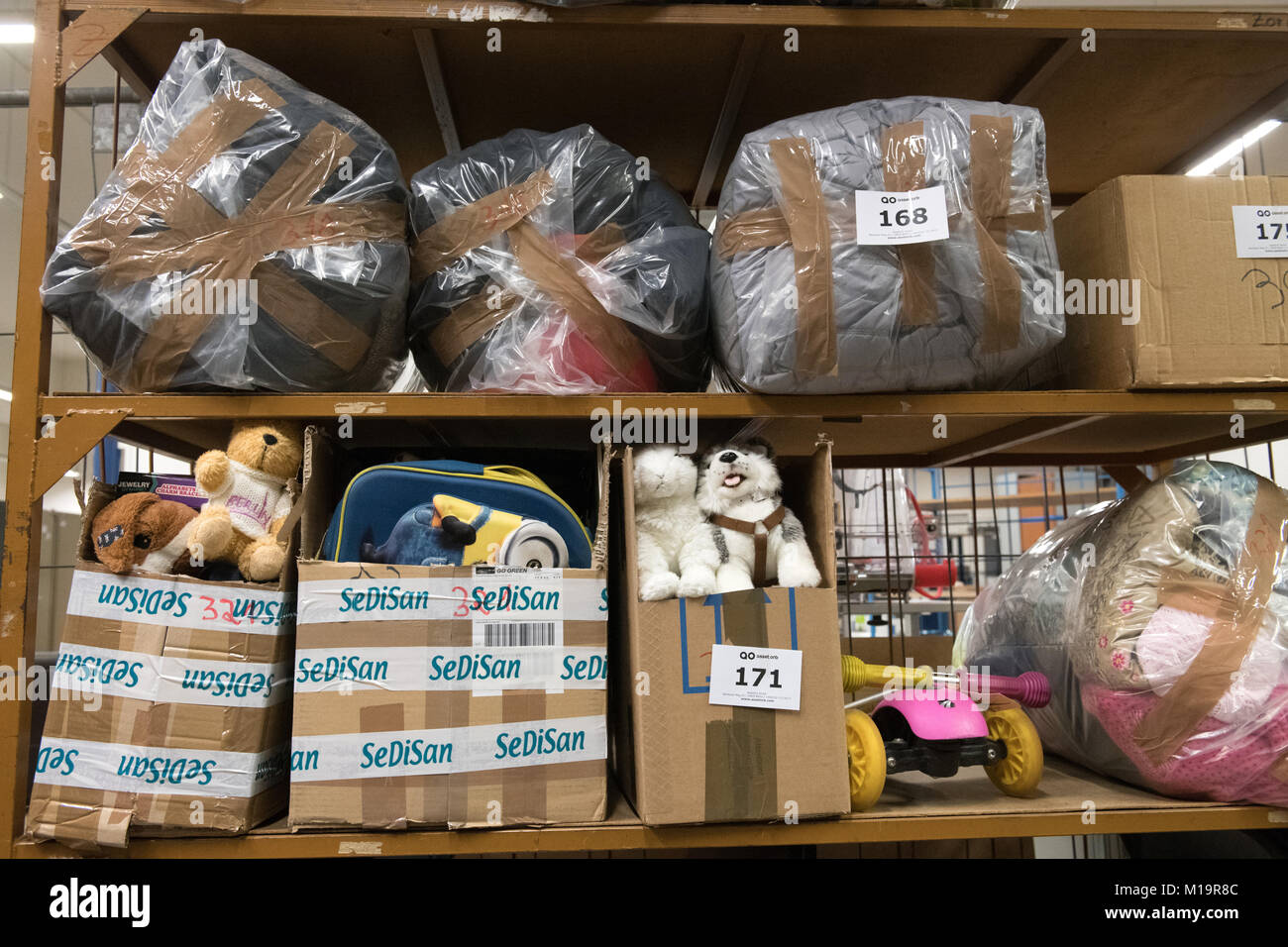 Boxes and bags of clothes on shelves at an auction house in Berlin ...