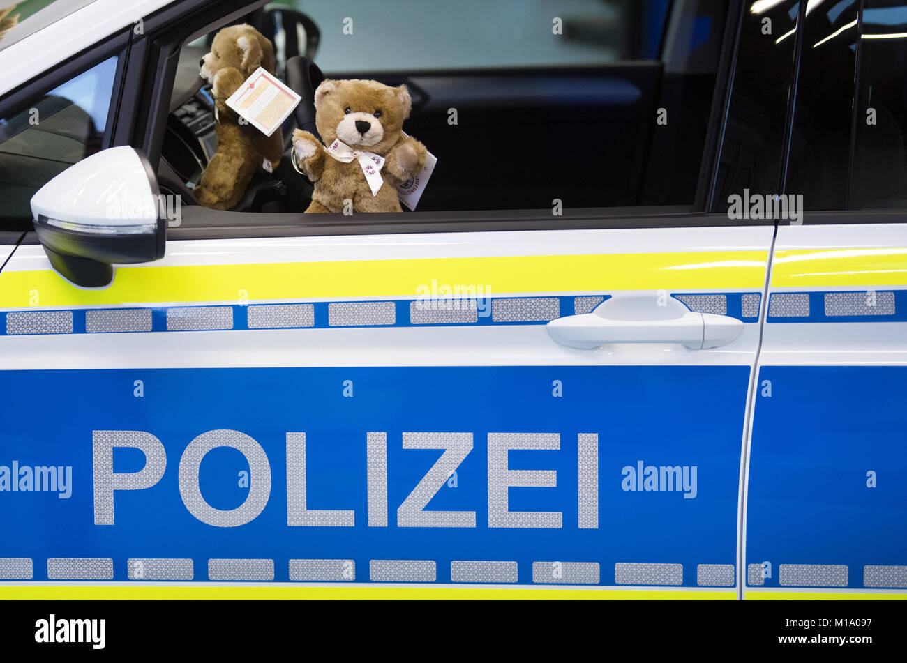 First examples of furry teddy bears are presented atop a police car ...