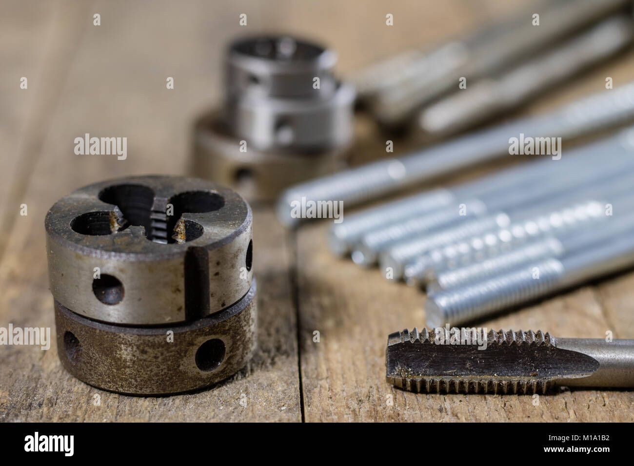 Metalwork tools on the workshop table. Threading dies and taps in an ...