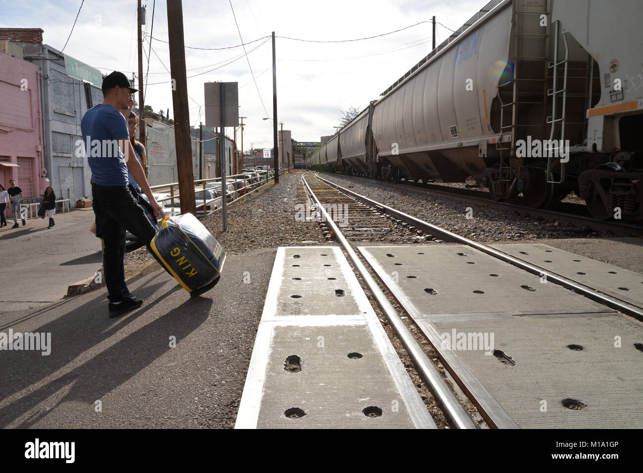 Pedestrians wait as a Union Pacific freight train carrying goods from ...