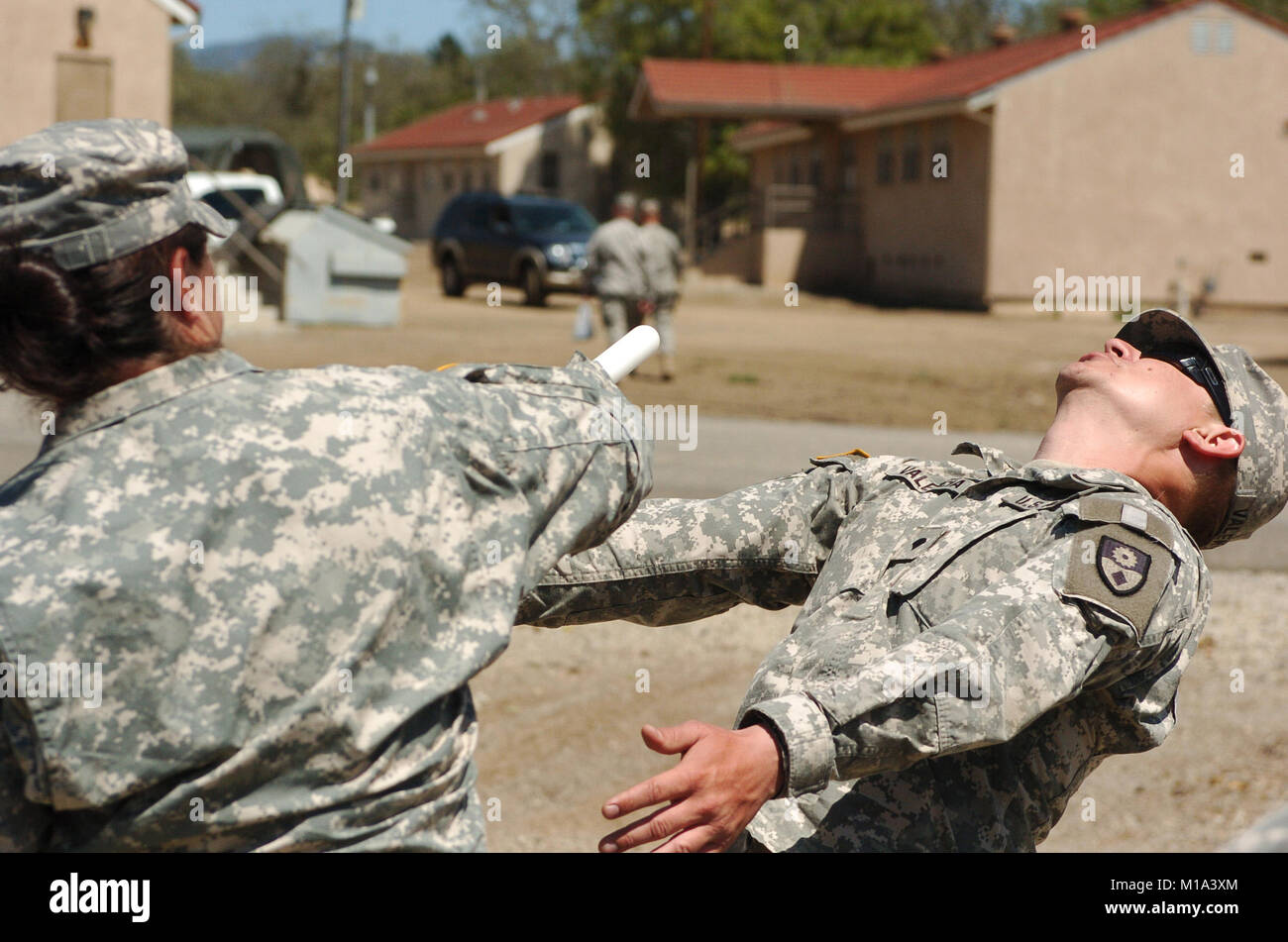 At right, Spc. Kevin Valencia dodges a baton strike by Staff Sgt ...
