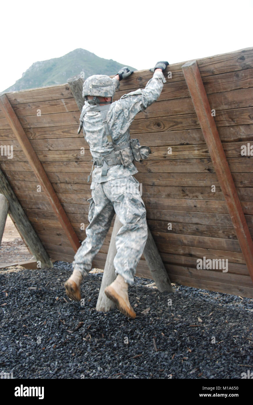 A Soldier jumps to clear the first wall during the obstacle course ...