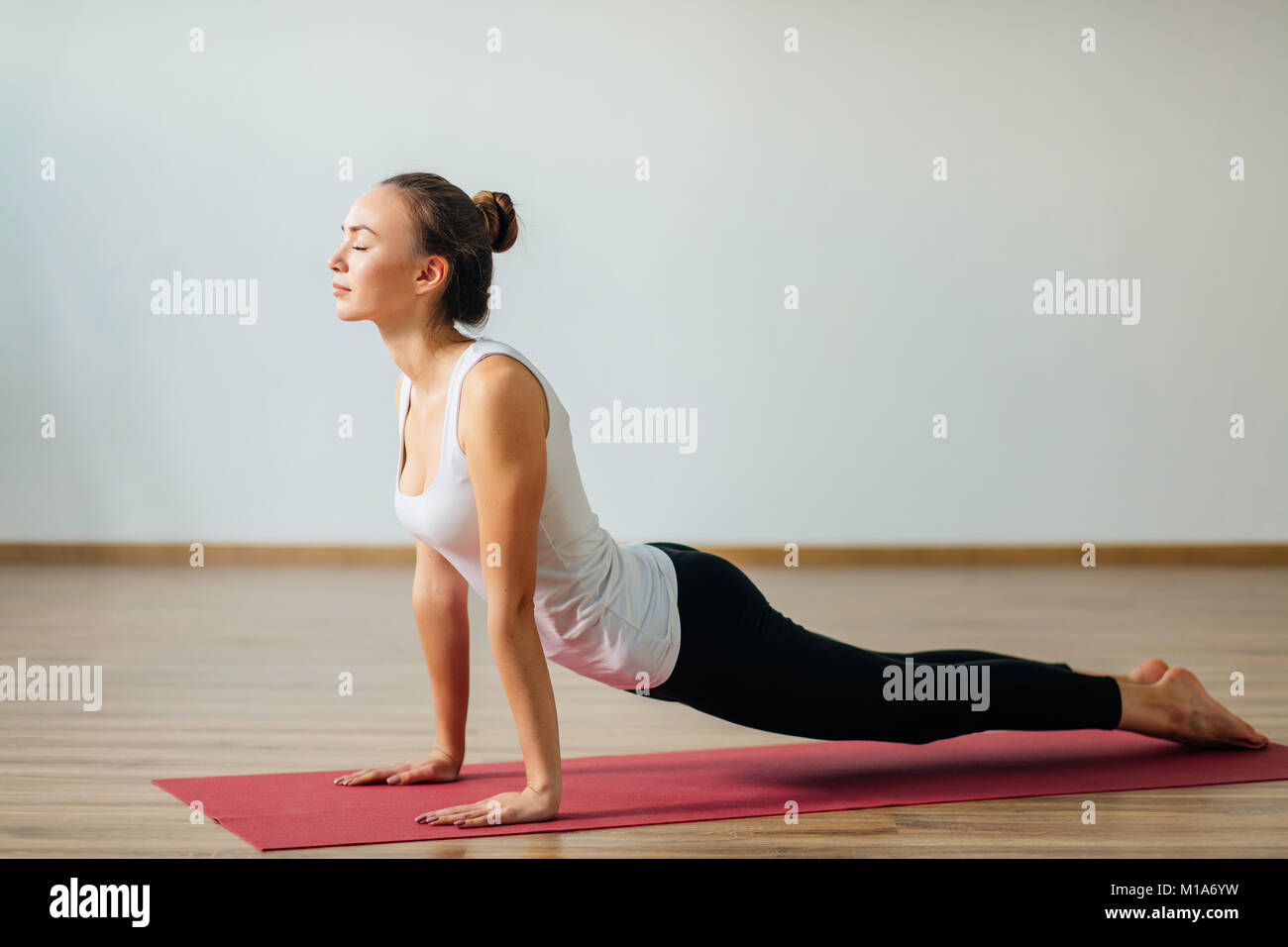 woman practicing yoga indoor. Beautiful girl practice cobra asana in class Stock Photo - Alamy