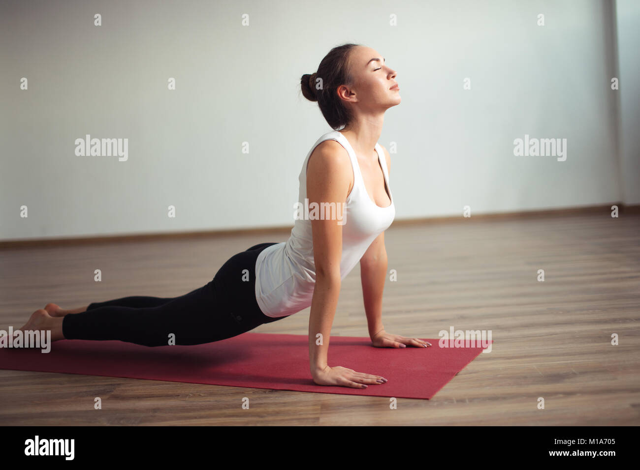 woman practicing yoga indoor. Beautiful girl practice cobra asana in class Stock Photo - Alamy