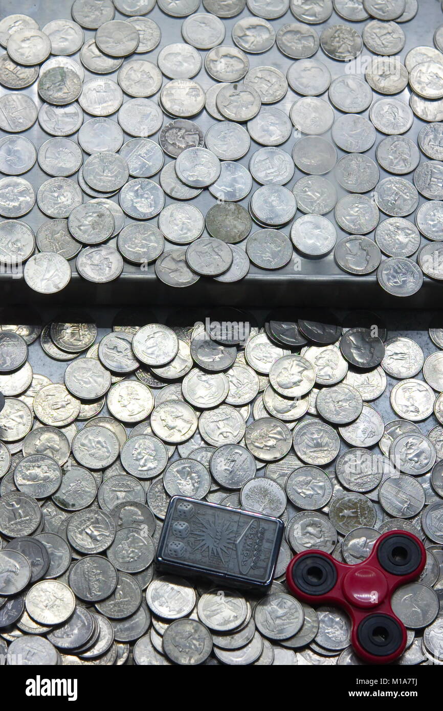 Quarter pusher arcade machine full of United States twenty five cent ...