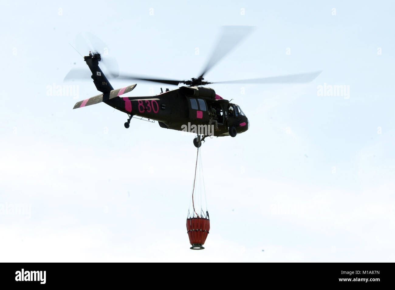 A UH-60 Blackhawk helicopter carrying a 500-gallon bucket takes off ...