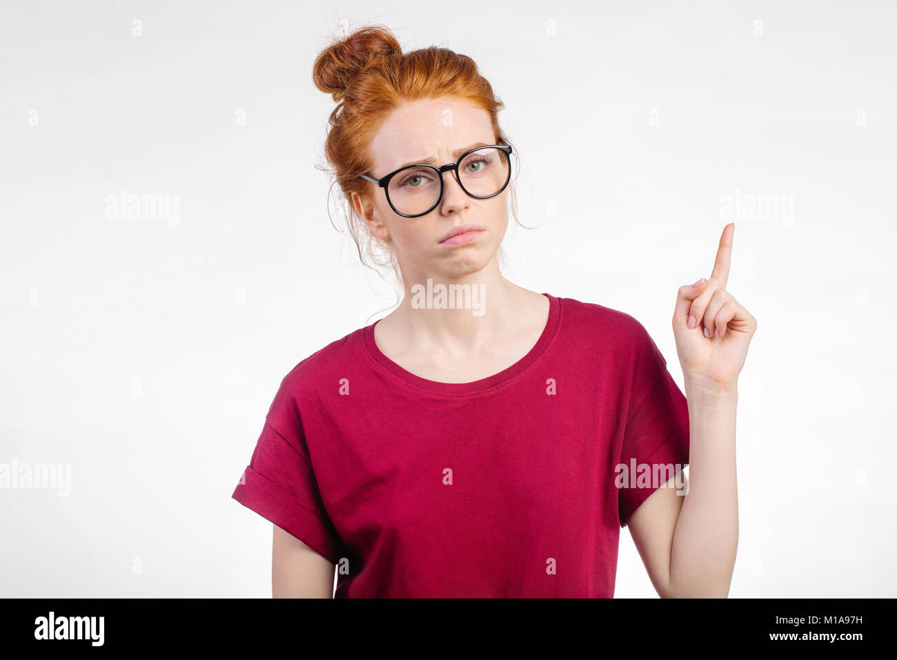 woman pointing up and looking camera. student gesturing her finger ...