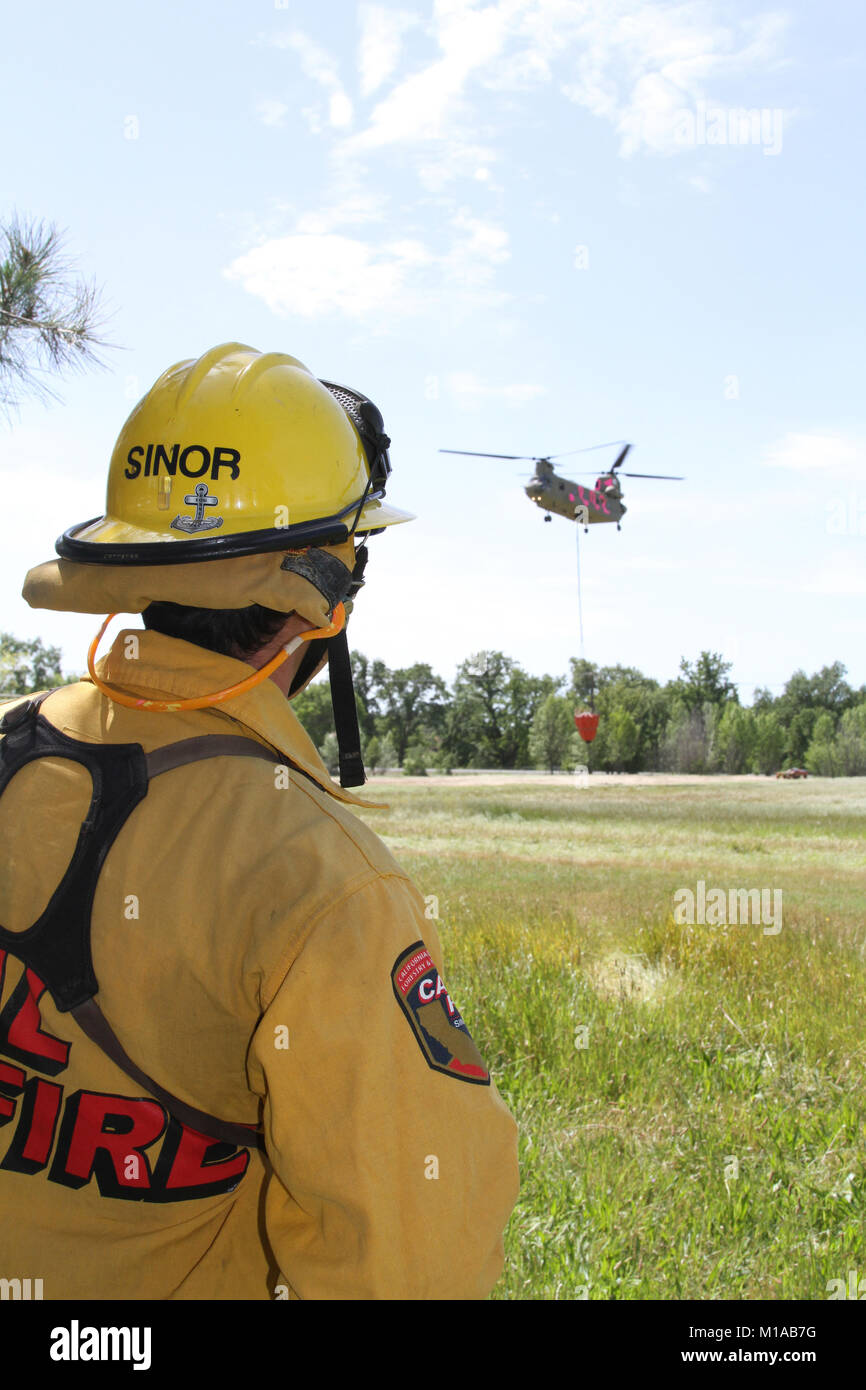 A CAL FIRE fireman watches a California National Guard CH-47 Chinook ...