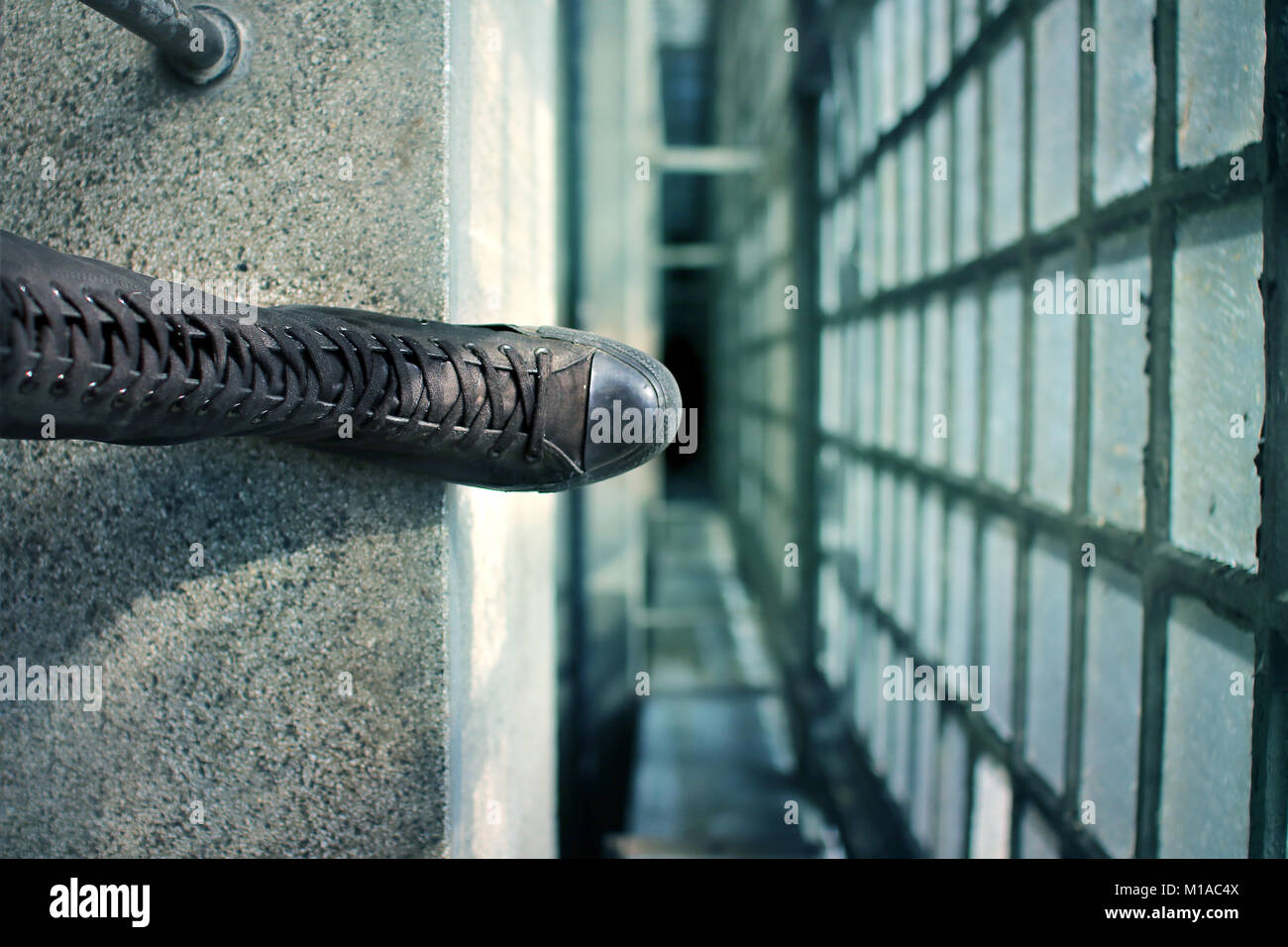 A shoe on the edge of a concrete building floor Stock Photo - Alamy
