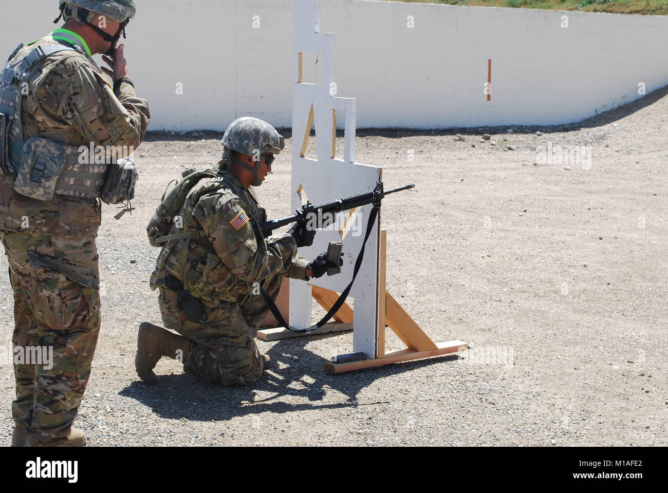 A soldier from the 330th Military Police Company reloads his weapon ...